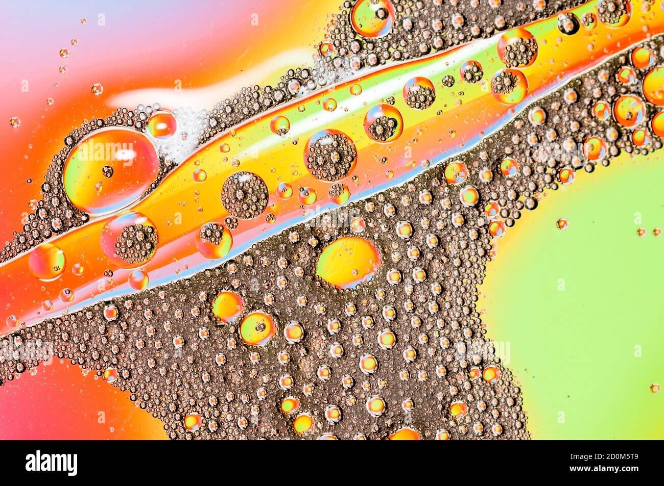 Oil drops on water surface lit from beneath Stock Photo - Alamy