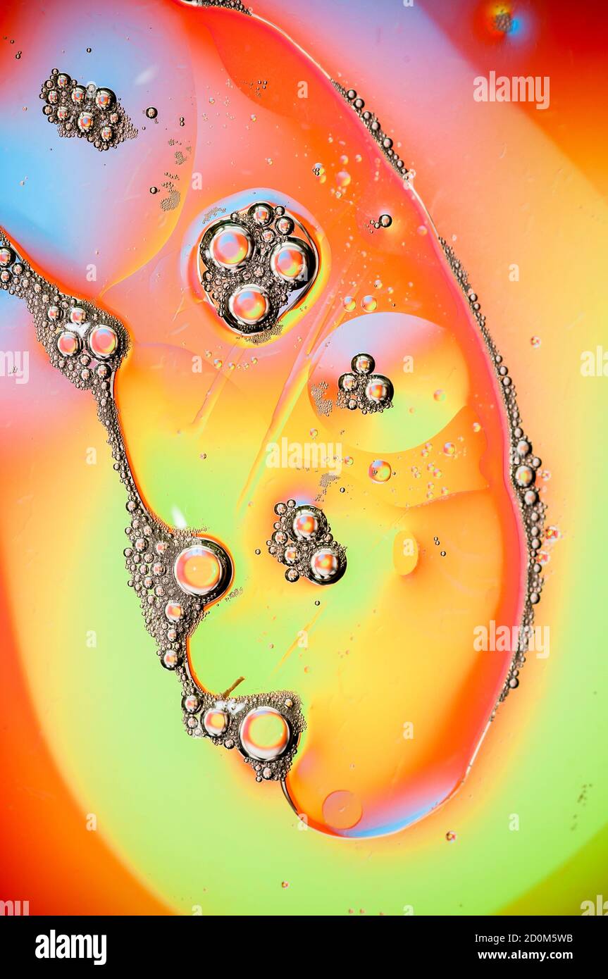Oil drops on water surface lit from beneath Stock Photo - Alamy