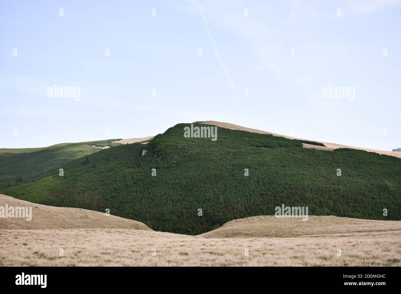 Horizontal shot of a green hilly terrain on the cloudless sky ...