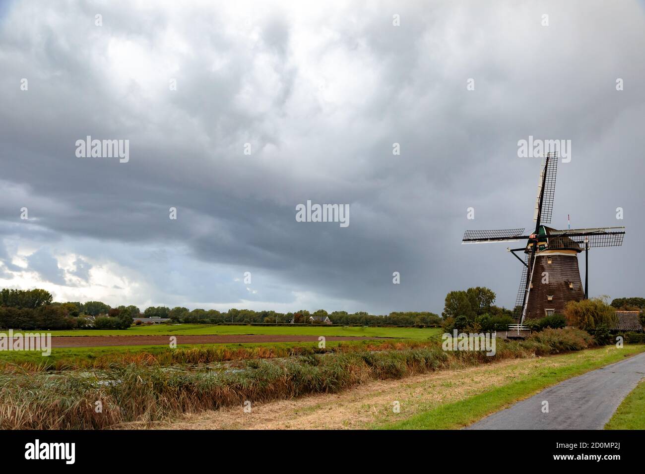 Ancient Dutch windmill under a dark cloudy sky Stock Photo - Alamy