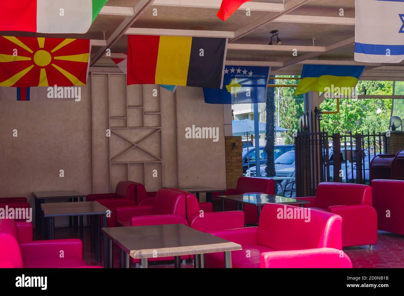 interior of street cafe decorated with national flags under the ceiling ...