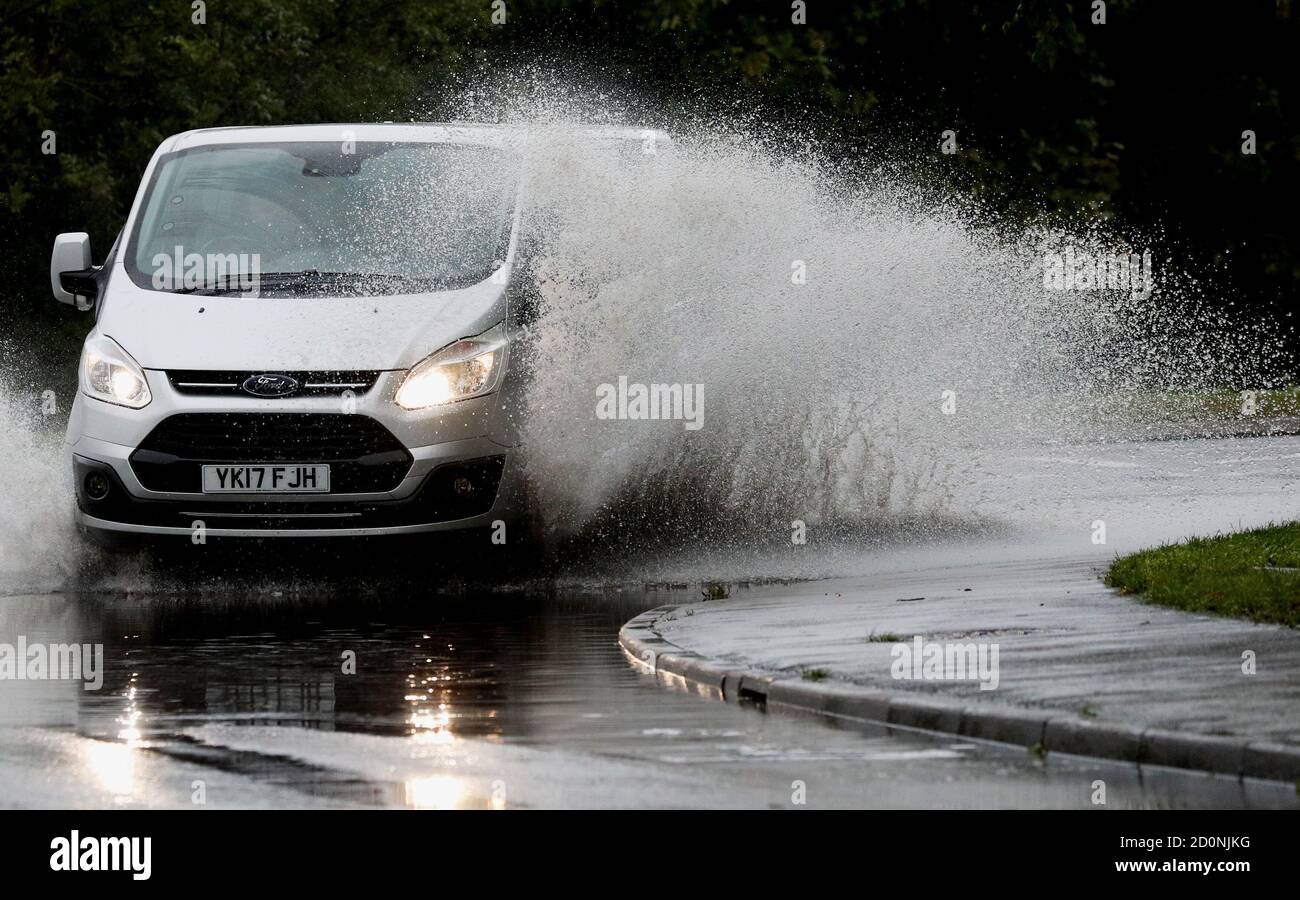 Vehicles generate spray as they pass through rainwater accumulated on a ...