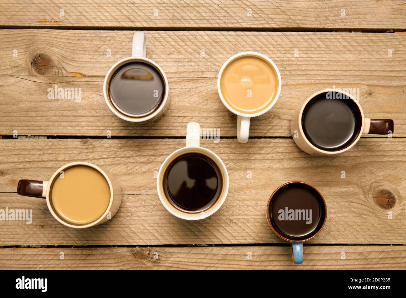 Many cups with tasty aromatic coffee on wooden table. Top view with ...