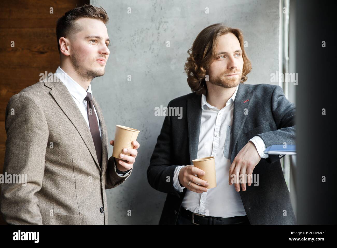 Two men in a suits are looking at the window Stock Photo - Alamy