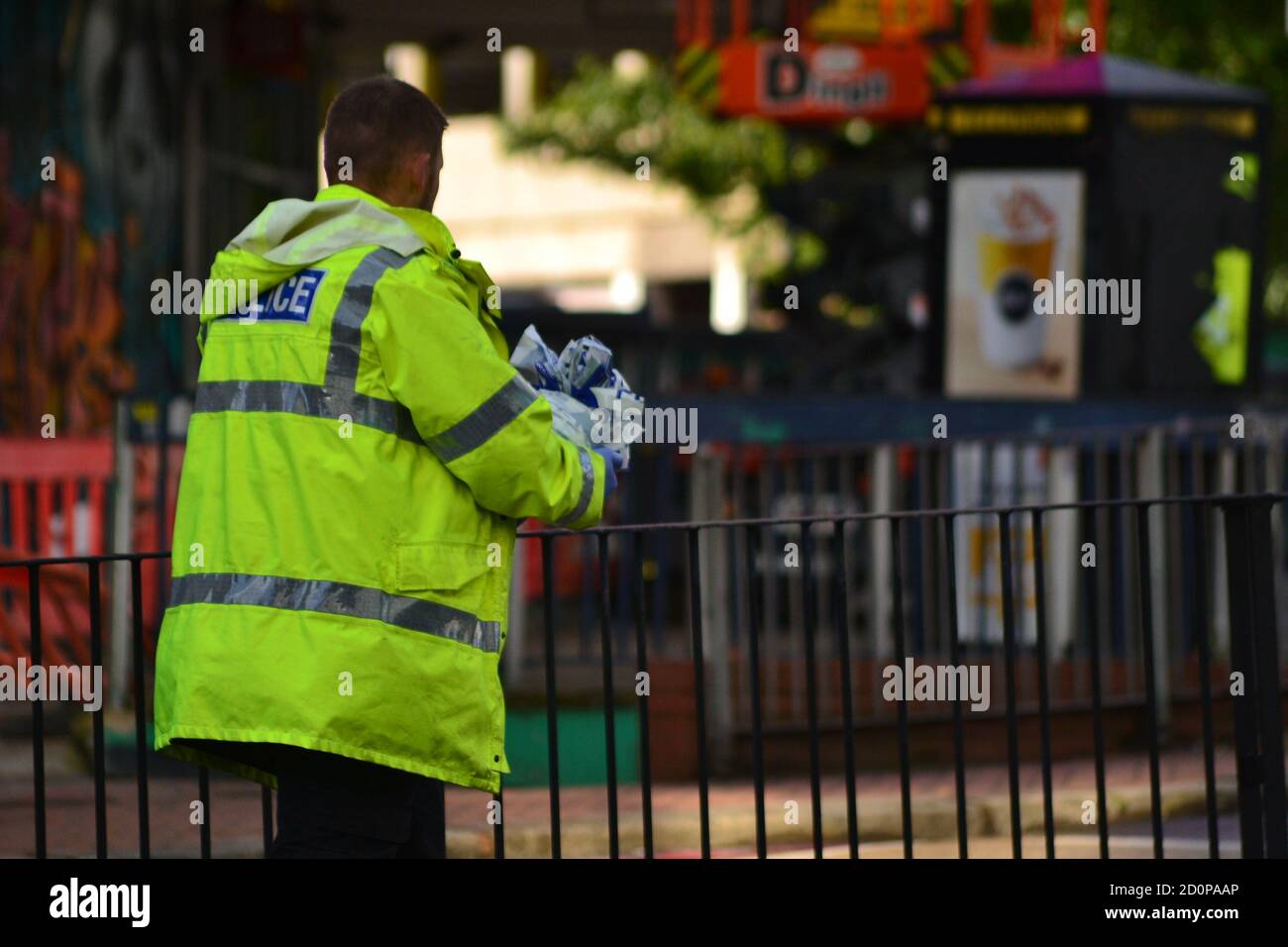 A police officer collects police tape after a car crash. West Midlands ...