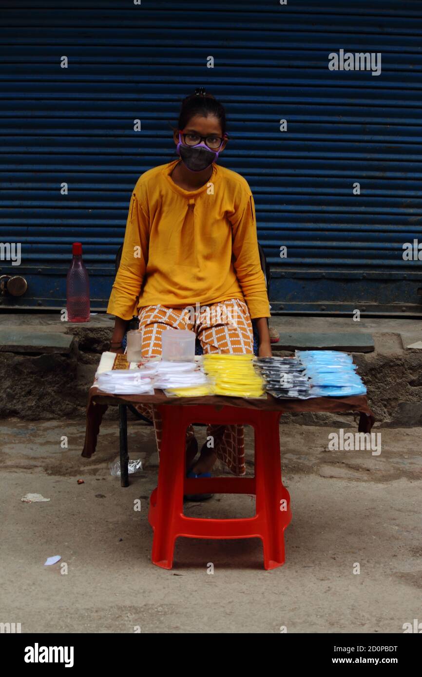 Vertical image of a small Indian girl who is selling masks Stock Photo ...