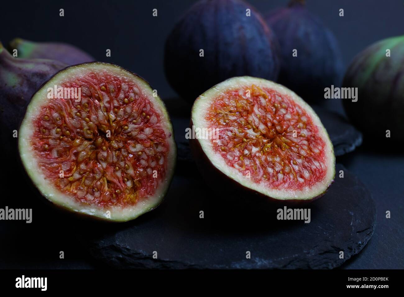 Macro closeup of two isolated fresh ripe sliced halves fig fruits wioth ...