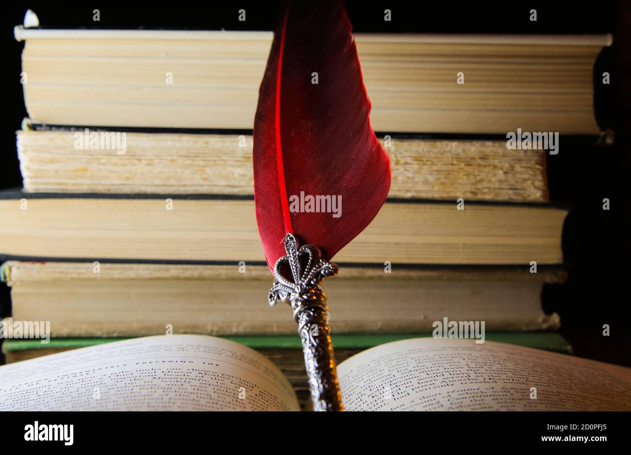 View on isolated antique red feather ink pen on pages of open book and ...