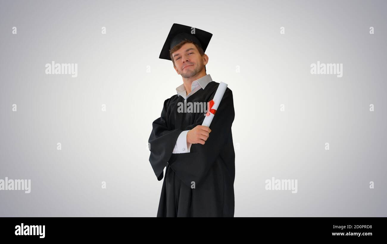 Proud male student in graduation gown posing with his diploma on Stock ...