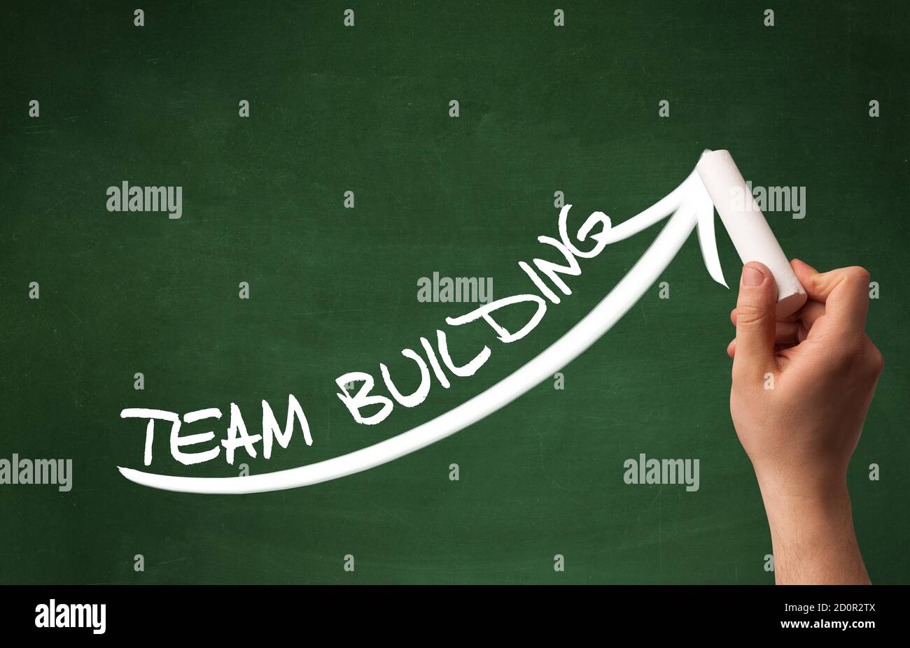 Hand drawing TEAM BUILDING inscription with white chalk on blackboard ...