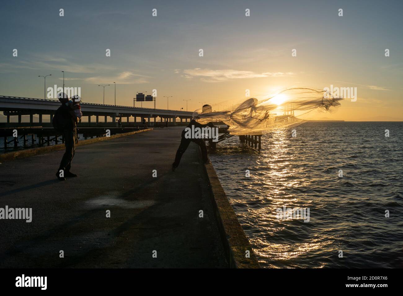 Batu Maung, Penang/Malaysia - Jan 01 2020: A man casting net to sea ...