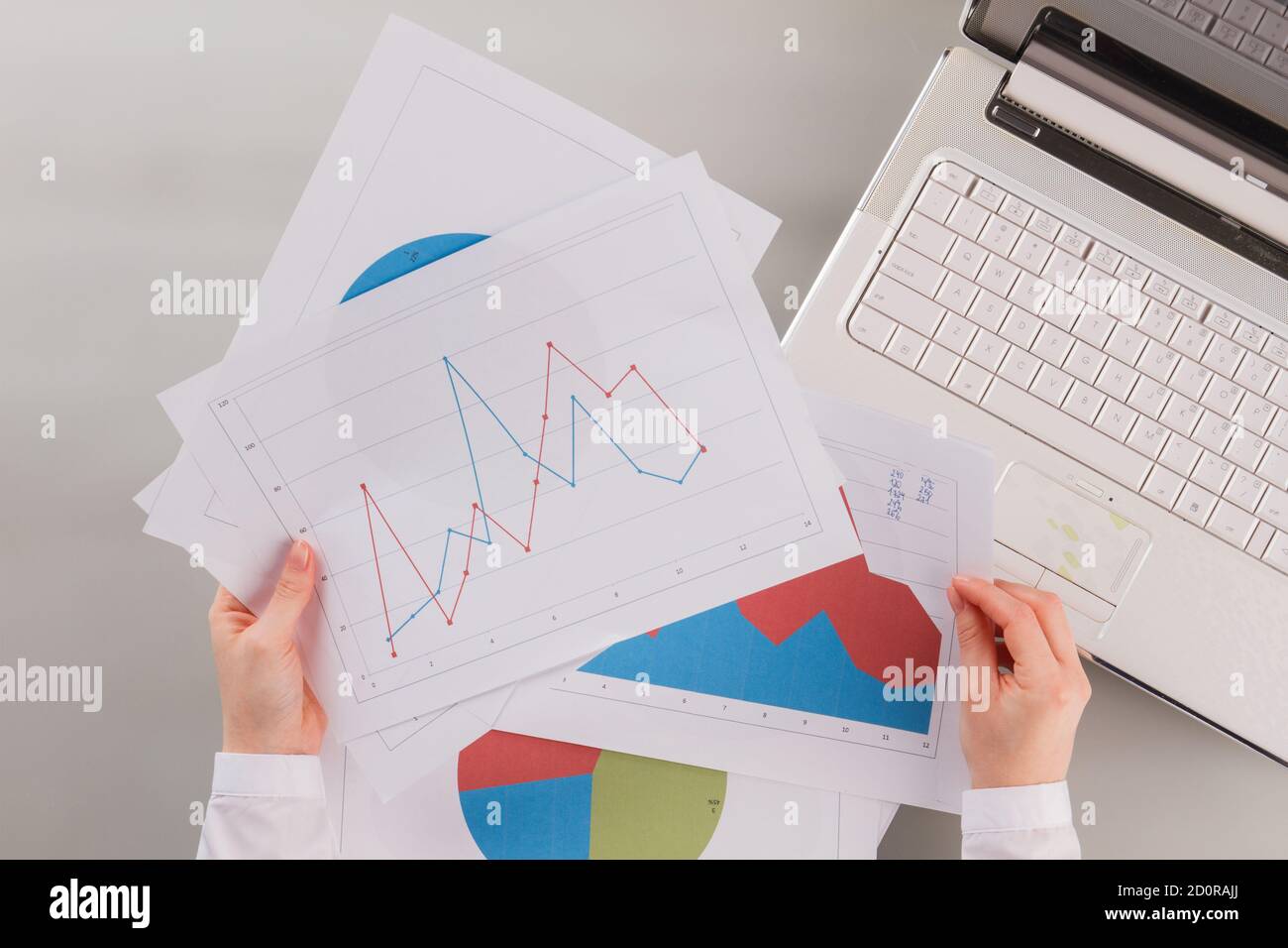 Female hands holding graphic charts Stock Photo - Alamy