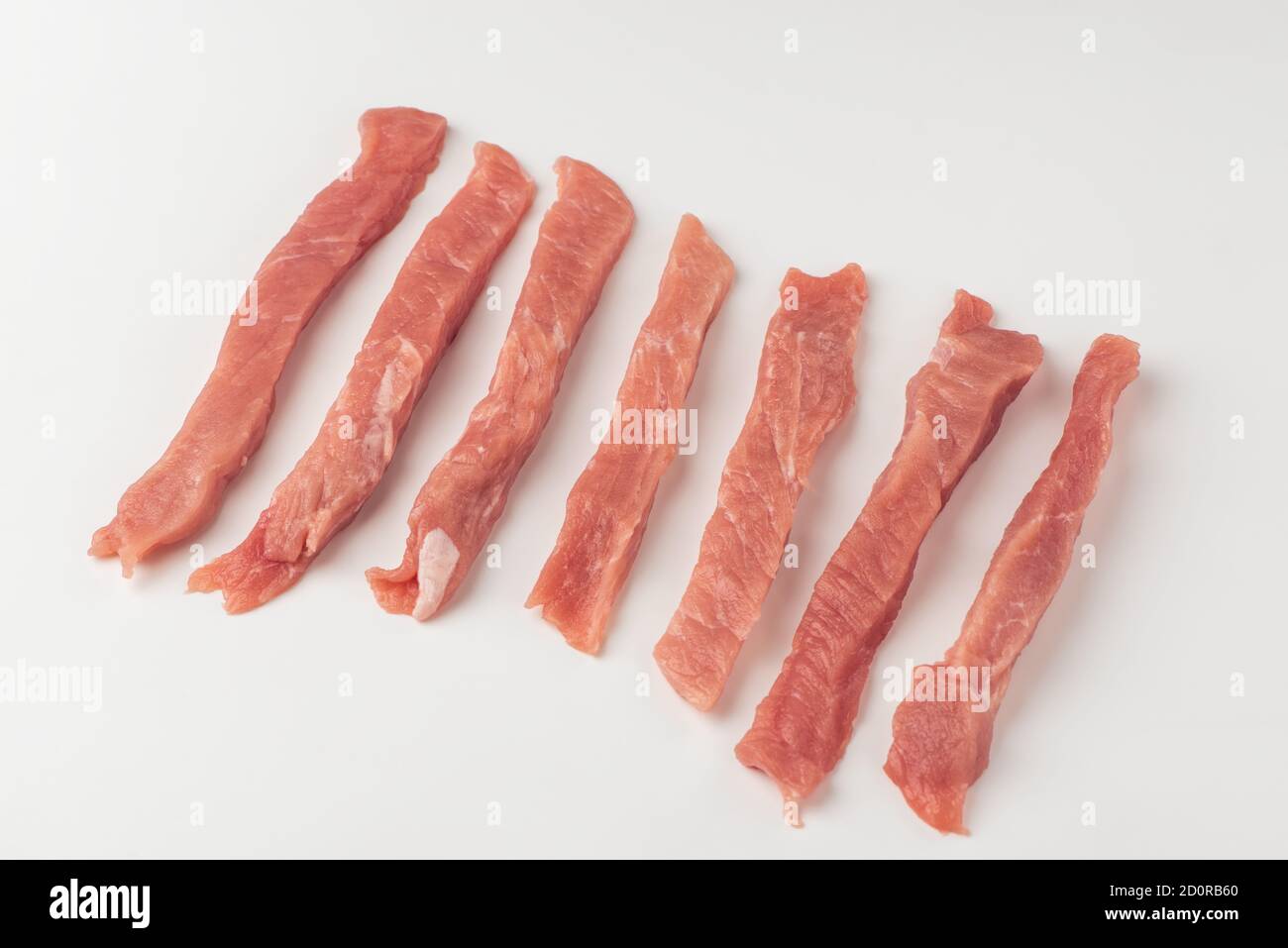 Top view on pork strips on white background Stock Photo - Alamy