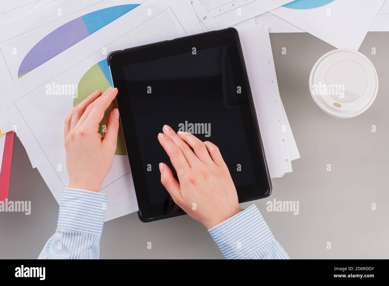 Workspace with female hands, digital tablet, documents and coffee cup ...