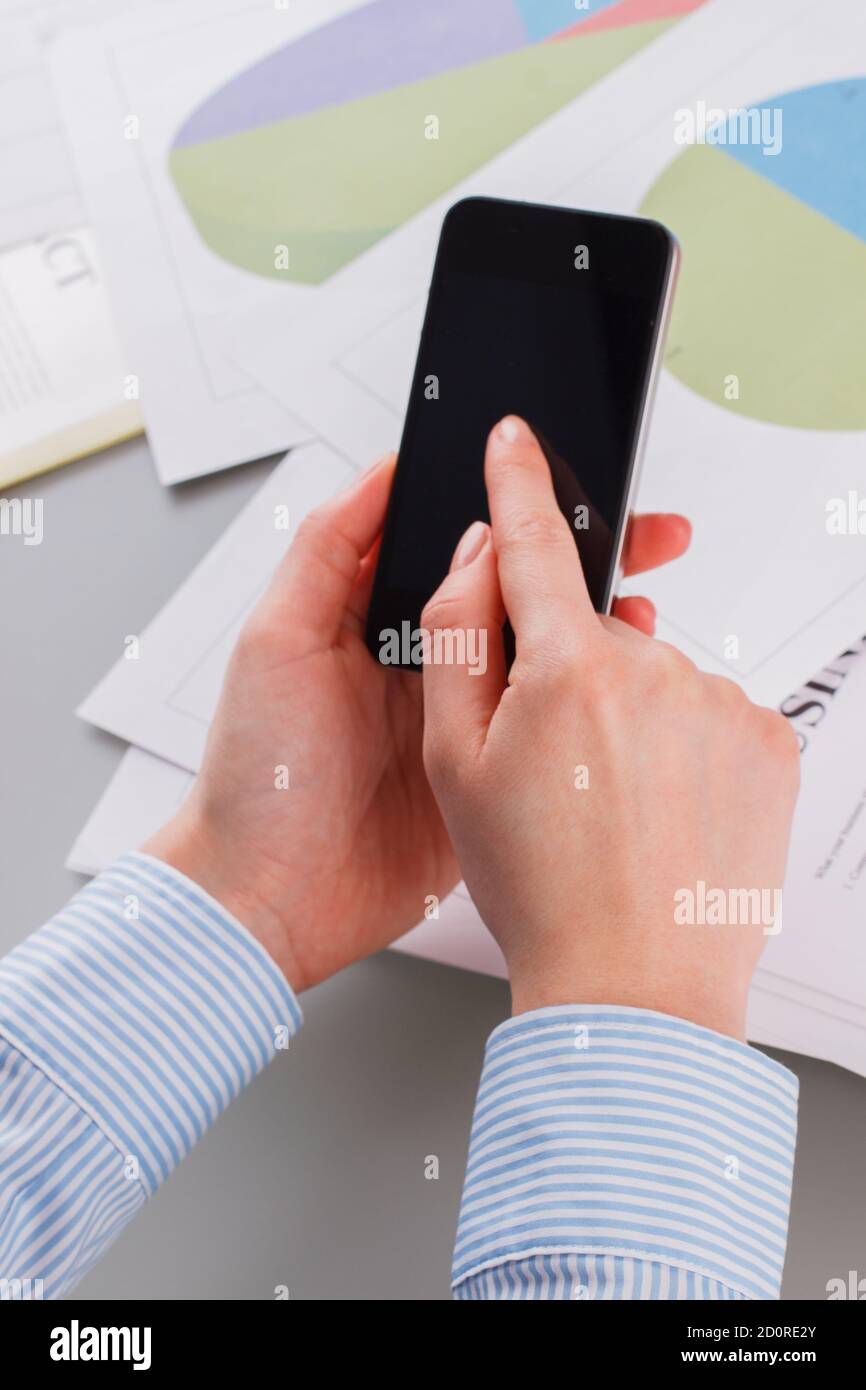 Female hands using smartphone at office Stock Photo - Alamy