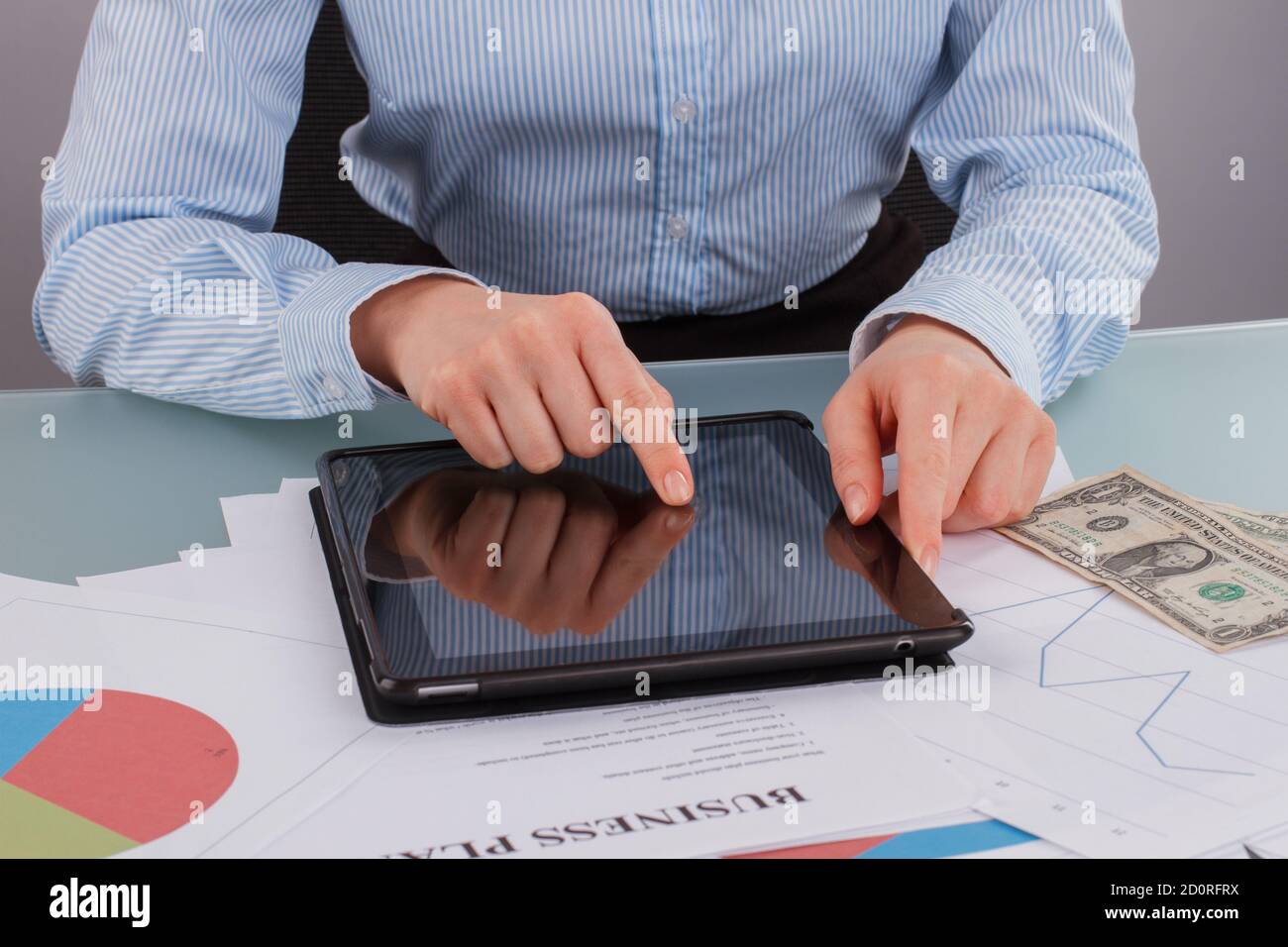 Hands of woman using pc tablet on table with documents Stock Photo - Alamy