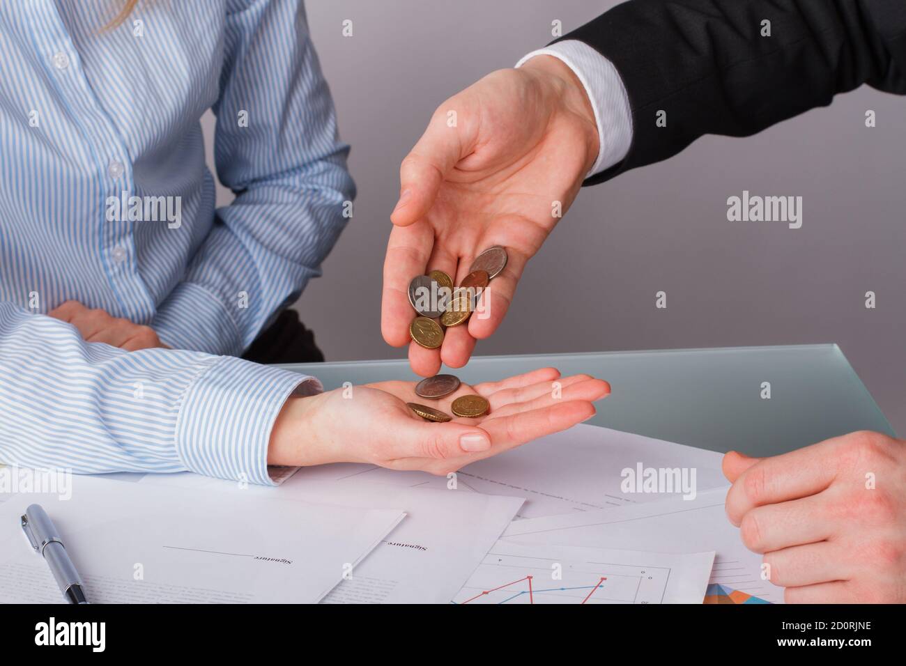 Businessman giving coins to business woman Stock Photo - Alamy