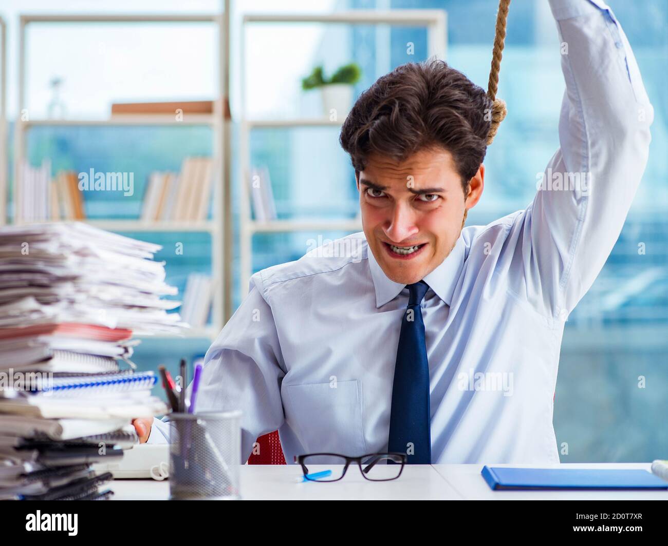 The unhappy businessman thinking of hanging himself in the office Stock ...