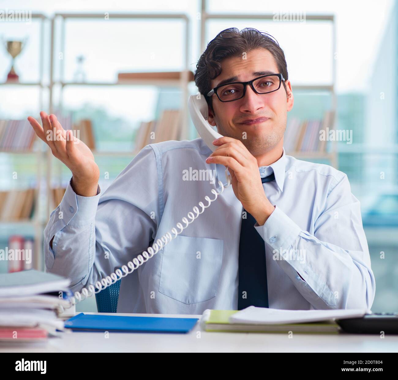 The unhappy call center employee taking another call Stock Photo - Alamy