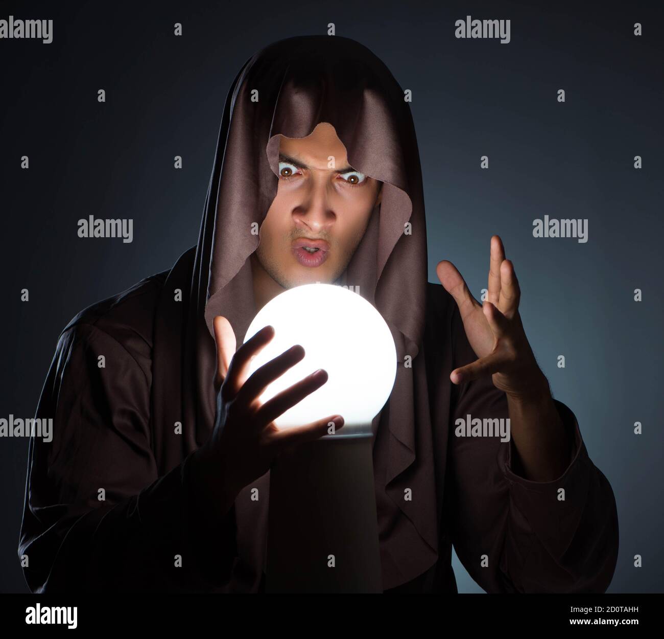 The young wizard with crystal ball in dark room Stock Photo - Alamy