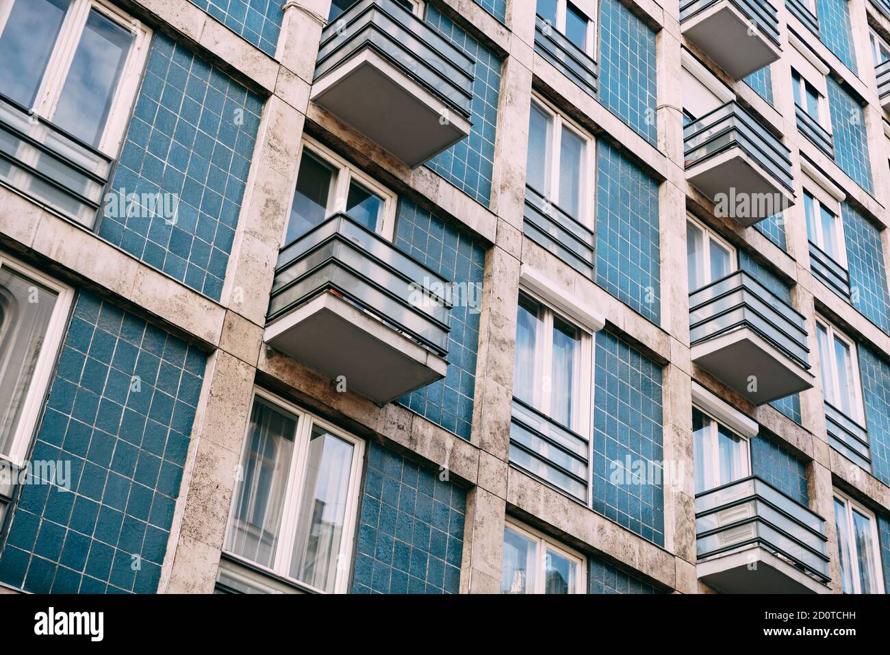 Tall blue multi-storey building with small balconies Stock Photo - Alamy