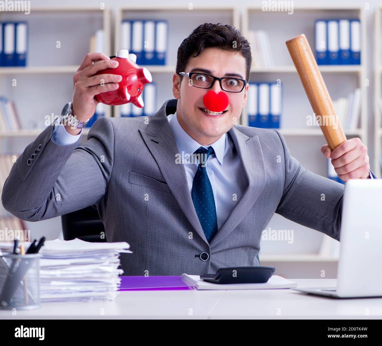 The clown businessman with a baseball bat and a piggy bank Stock Photo ...