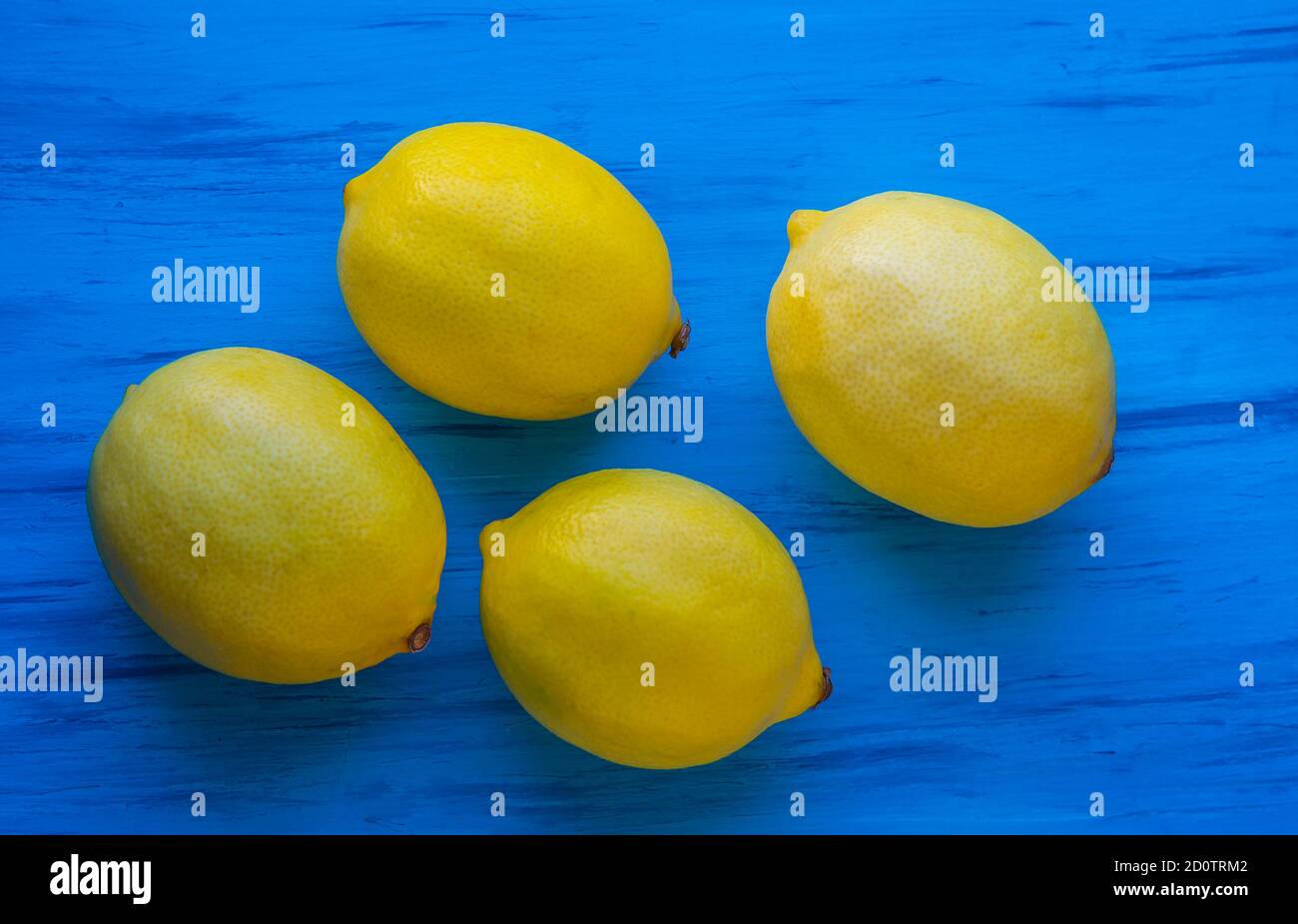 Ripe lemons on the blue background Stock Photo - Alamy