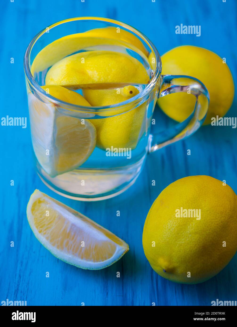Water with lemon in a glass on the blue background Stock Photo - Alamy