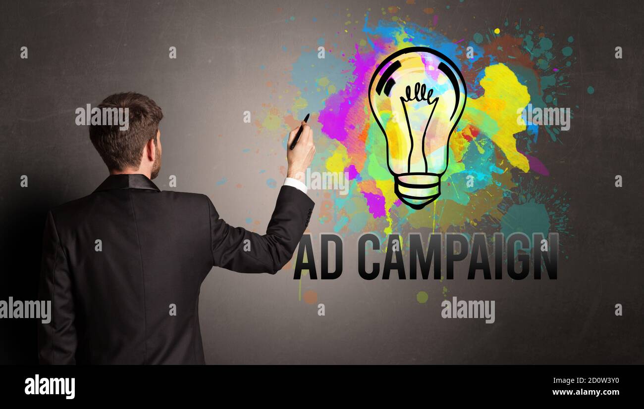 businessman drawing colorful light bulb with AD CAMPAIGN inscription on ...