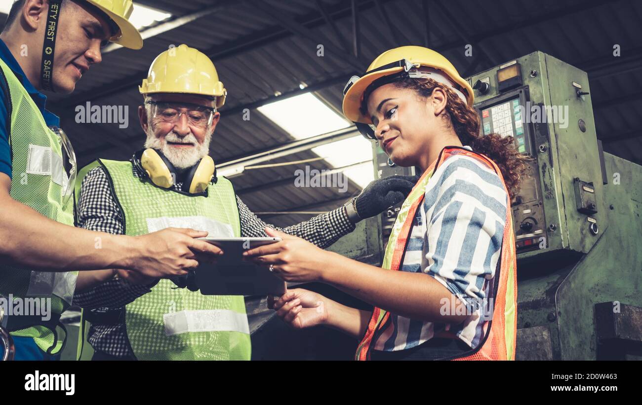 Group of factory workers using machine equipment in factory workshop ...