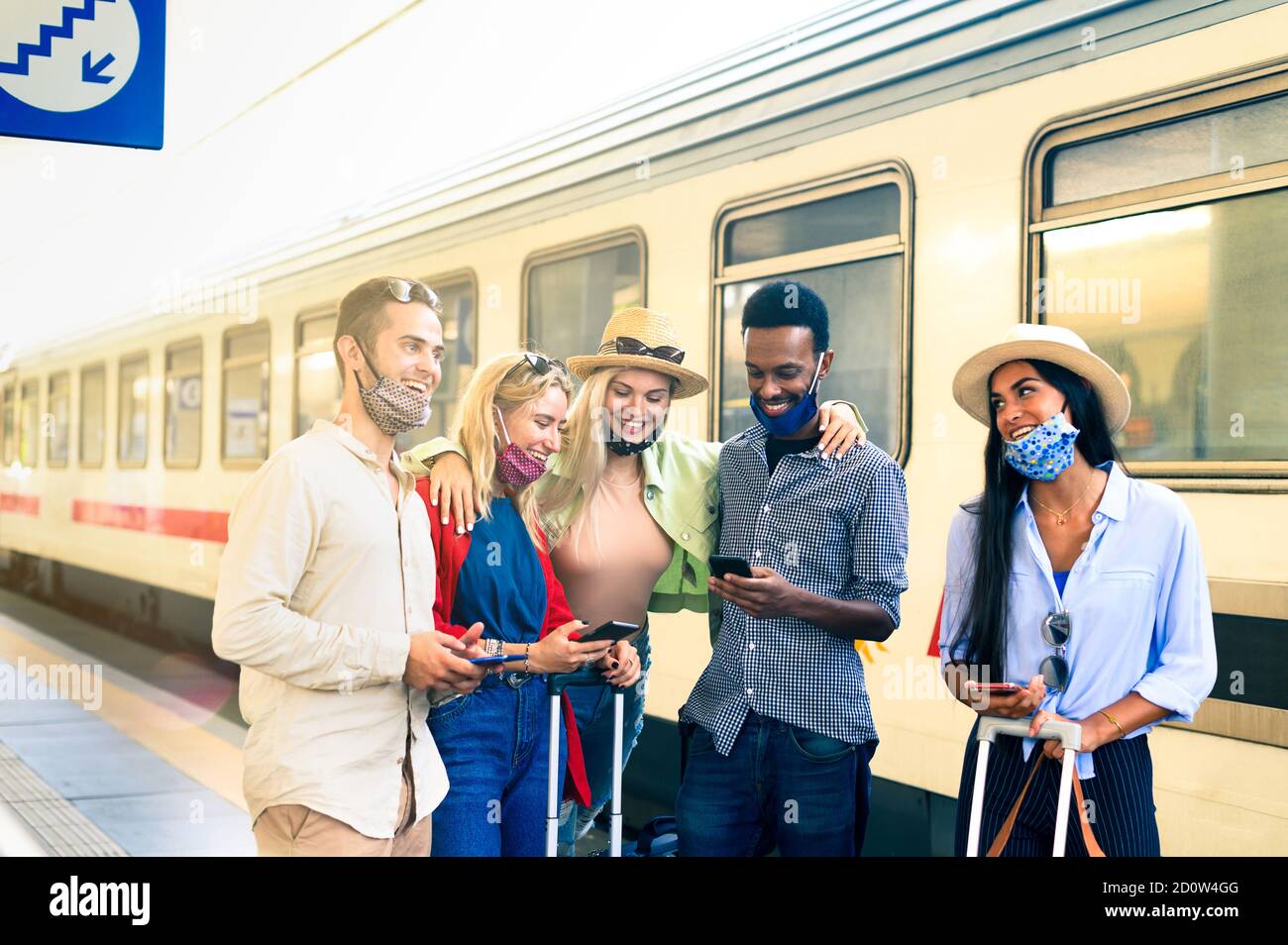 Group of happy smiling young people using mobile phones in train ...