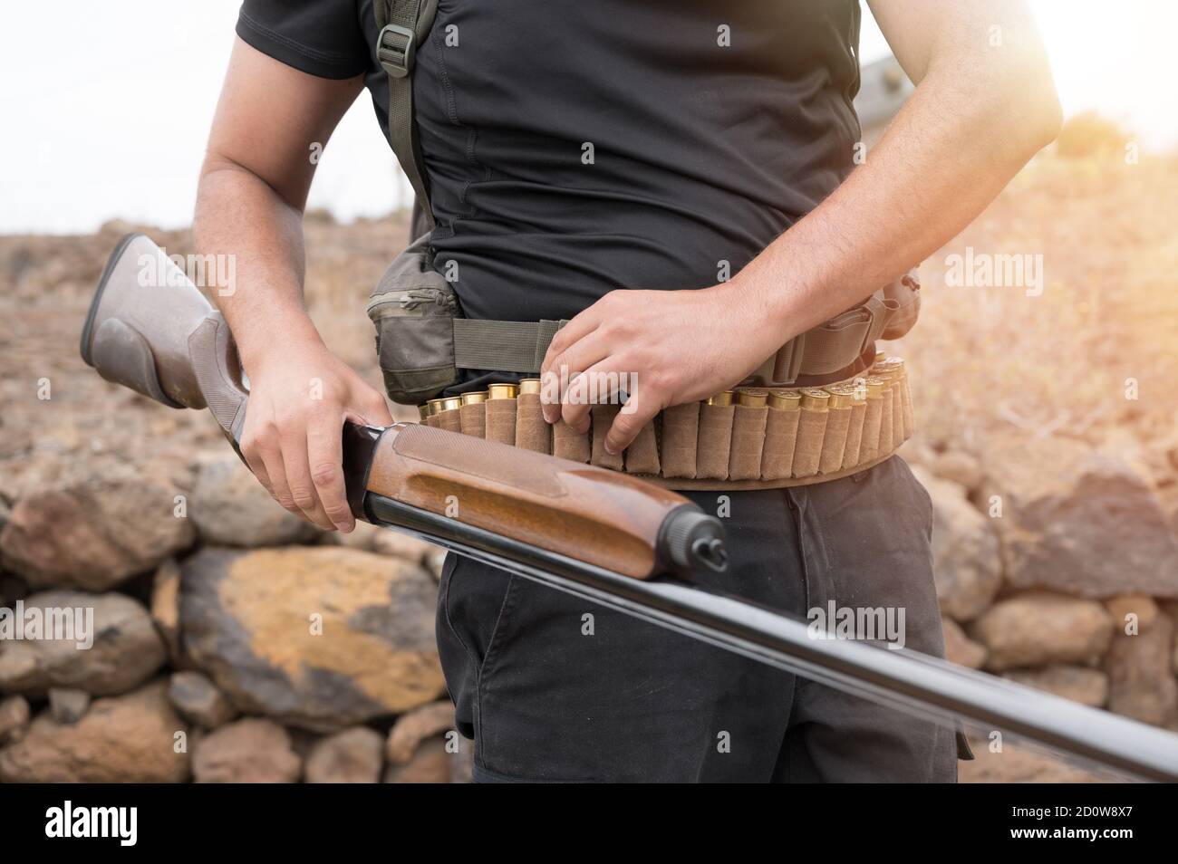 Close up of an unrecognizable hunter, loading shotgun, holds a shotgun ...