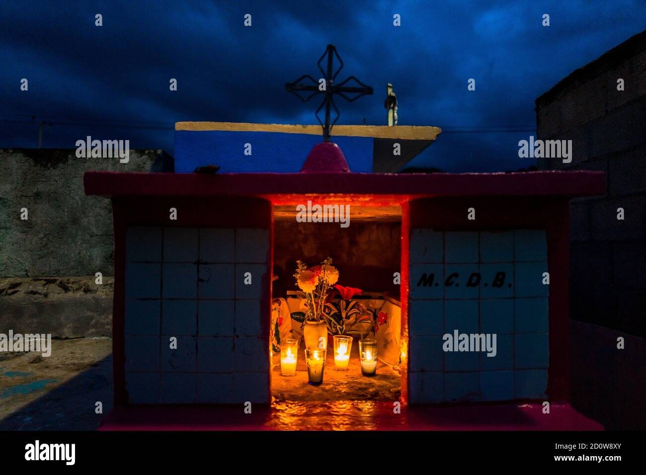 Burning candles, flowers and wooden crates are seen placed inside a ...