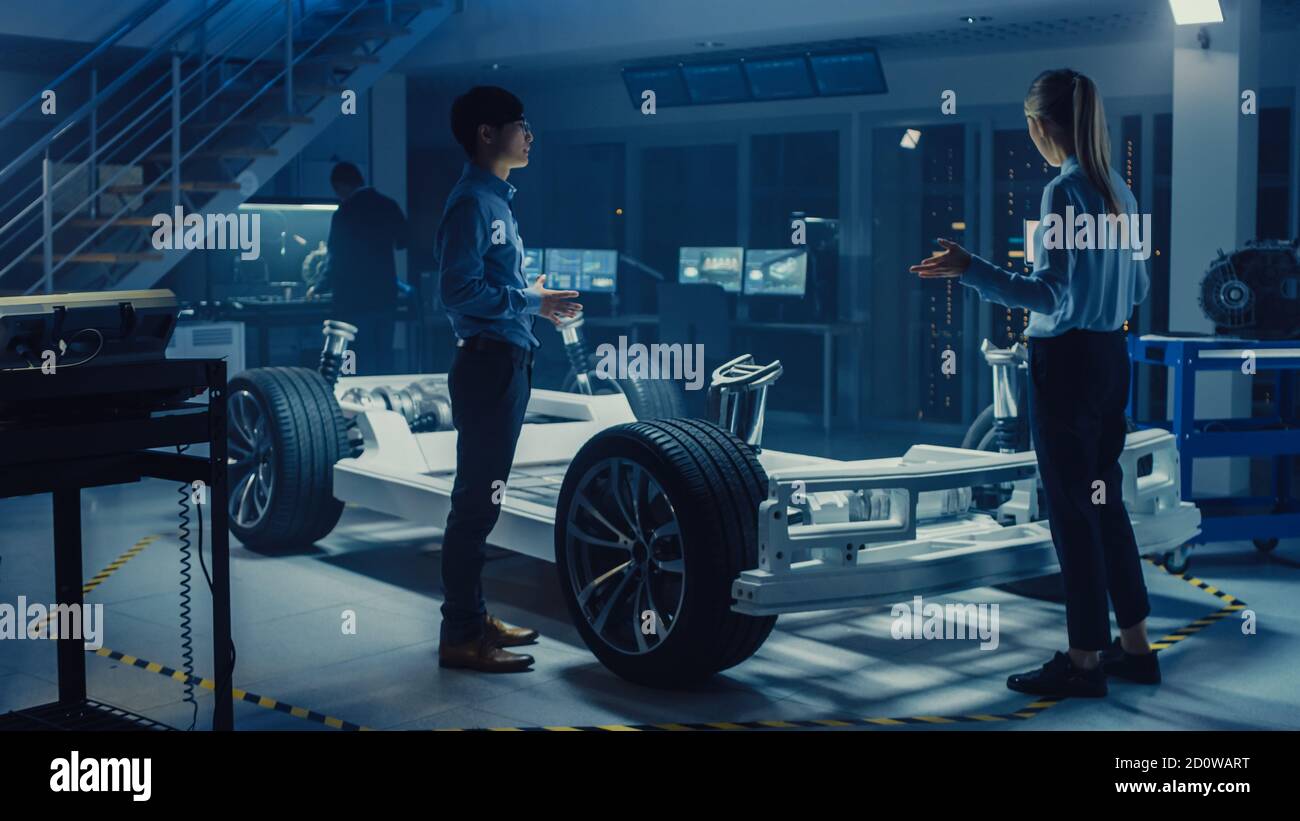 Automotive Design Engineers Talking while Working on Electric Car ...