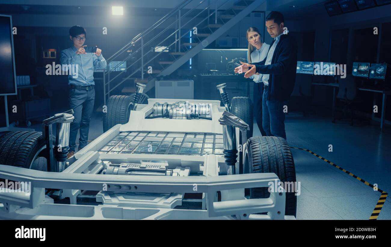 Automotive Design Engineers Talking while Working on Electric Car ...