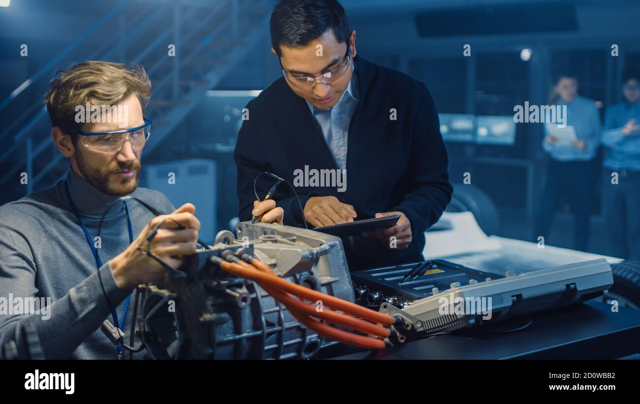 Two Professional Automotive Engineers with a Tablet Computer and ...