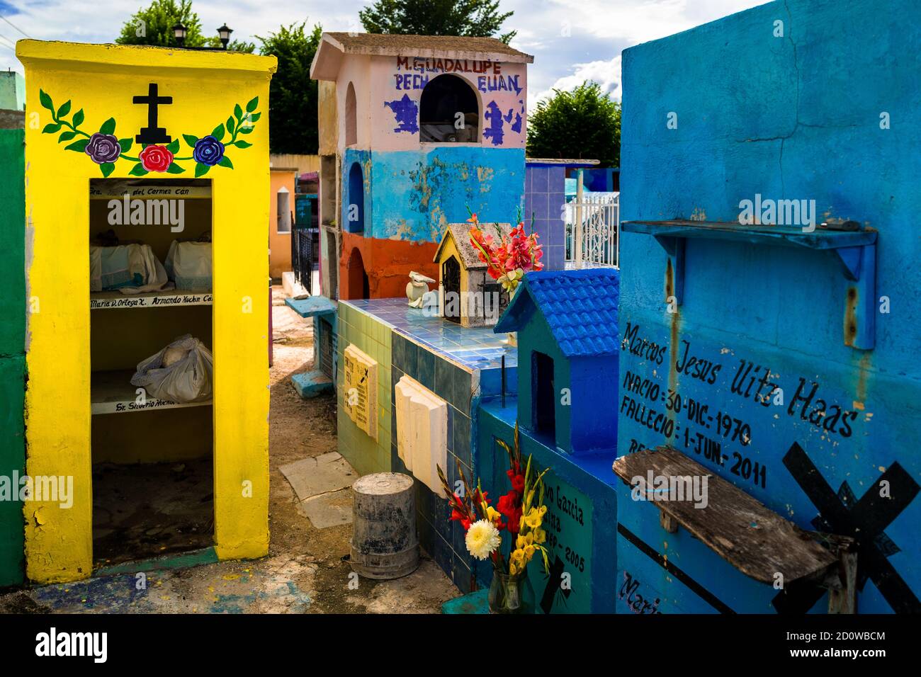 Colorful niches and above-ground tombs, adorned with flowers, are seen ...