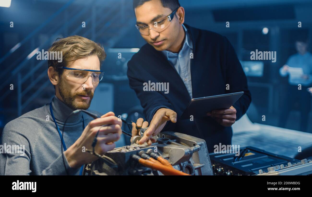 Two Professional Automotive Engineers with a Tablet Computer and ...