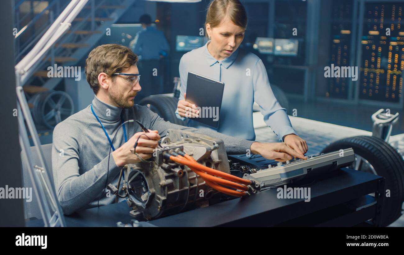 Male and Female Automotive Engineers with a Tablet Computer and ...