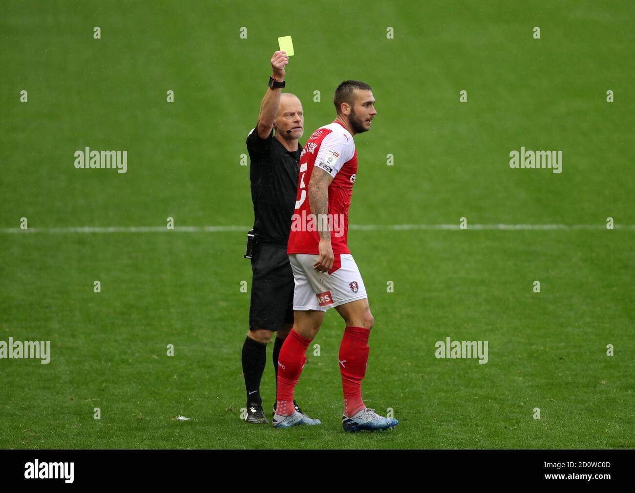 Match referee Andy Woolmer shows a yellow card to Rotherham United's ...
