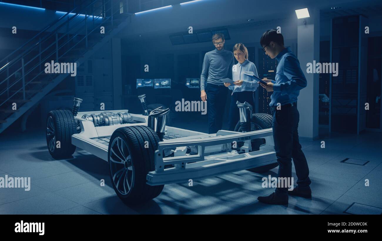 Diverse Automobile Engineers Talking while Working on Electric Car ...