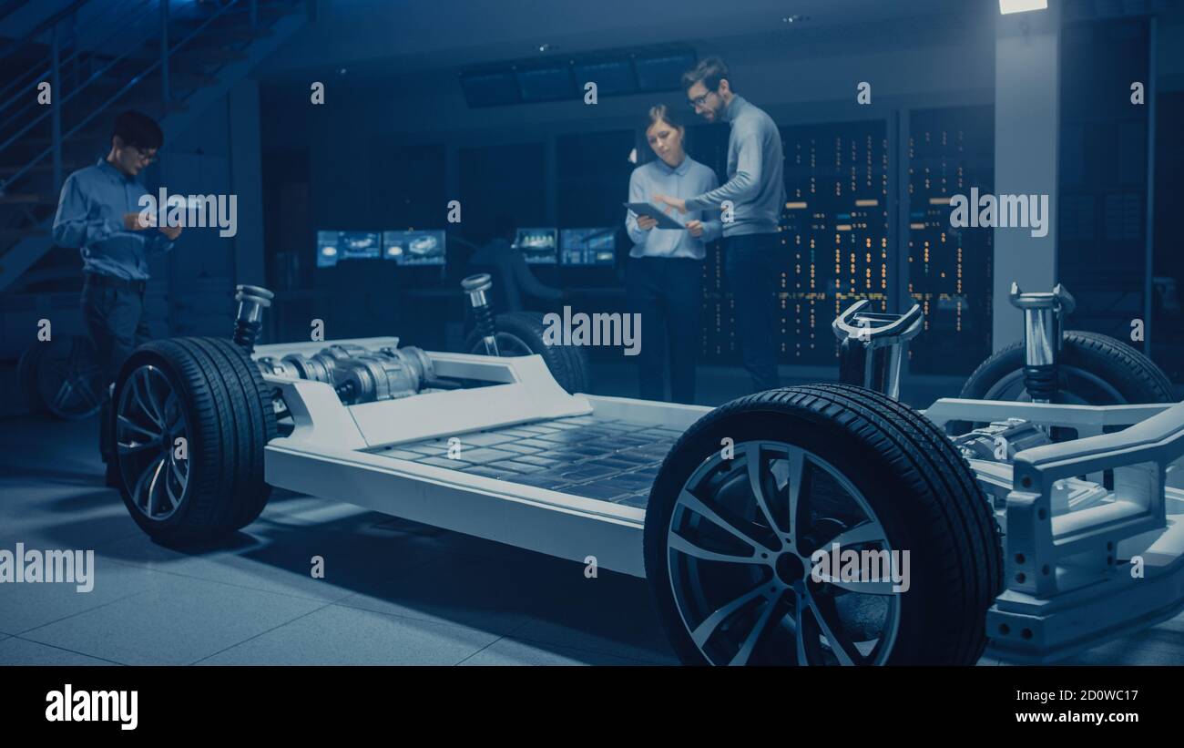 Diverse Automobile Engineers Talking while Working on Electric Car ...