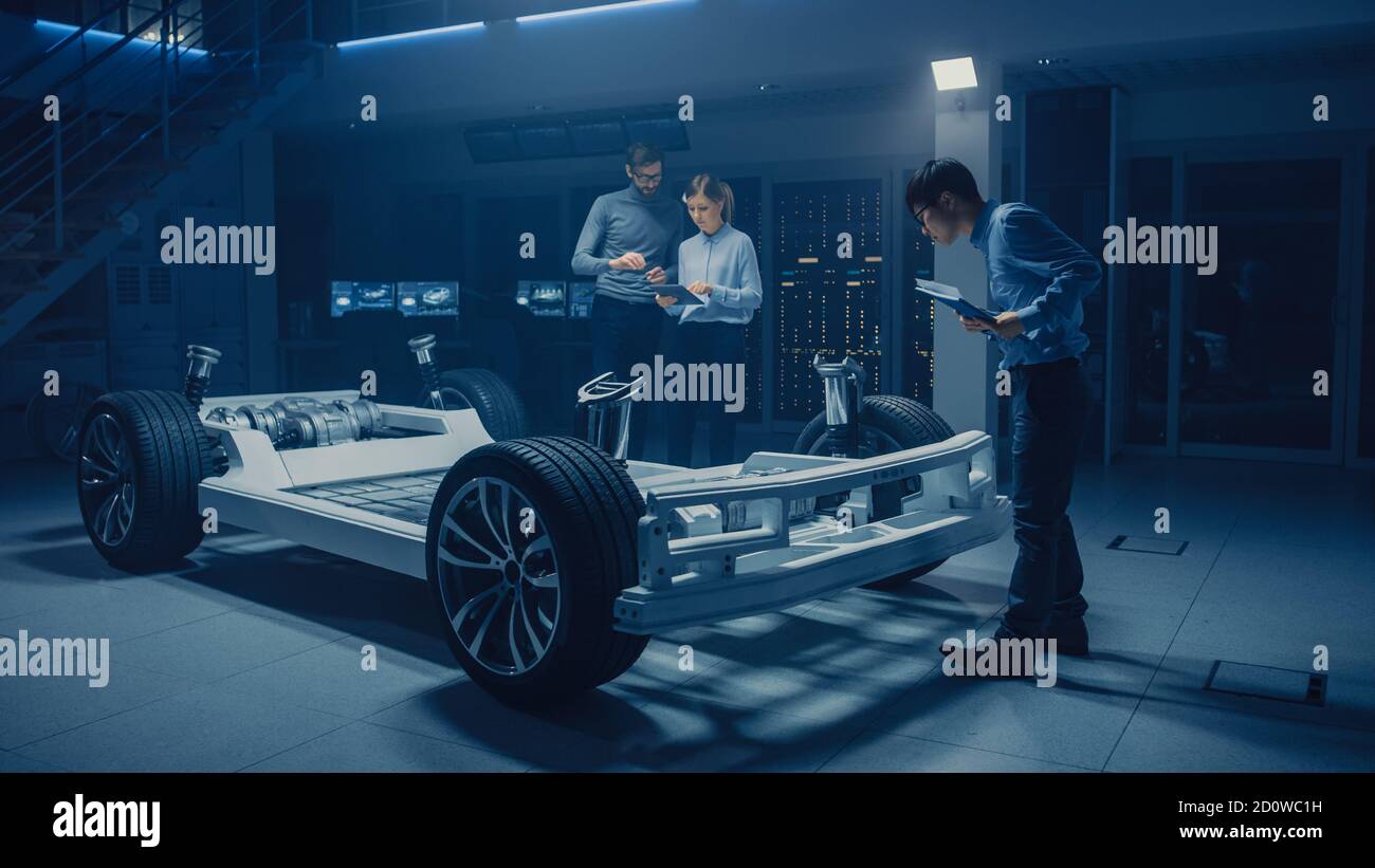 Diverse Automobile Engineers Talking while Working on Electric Car ...