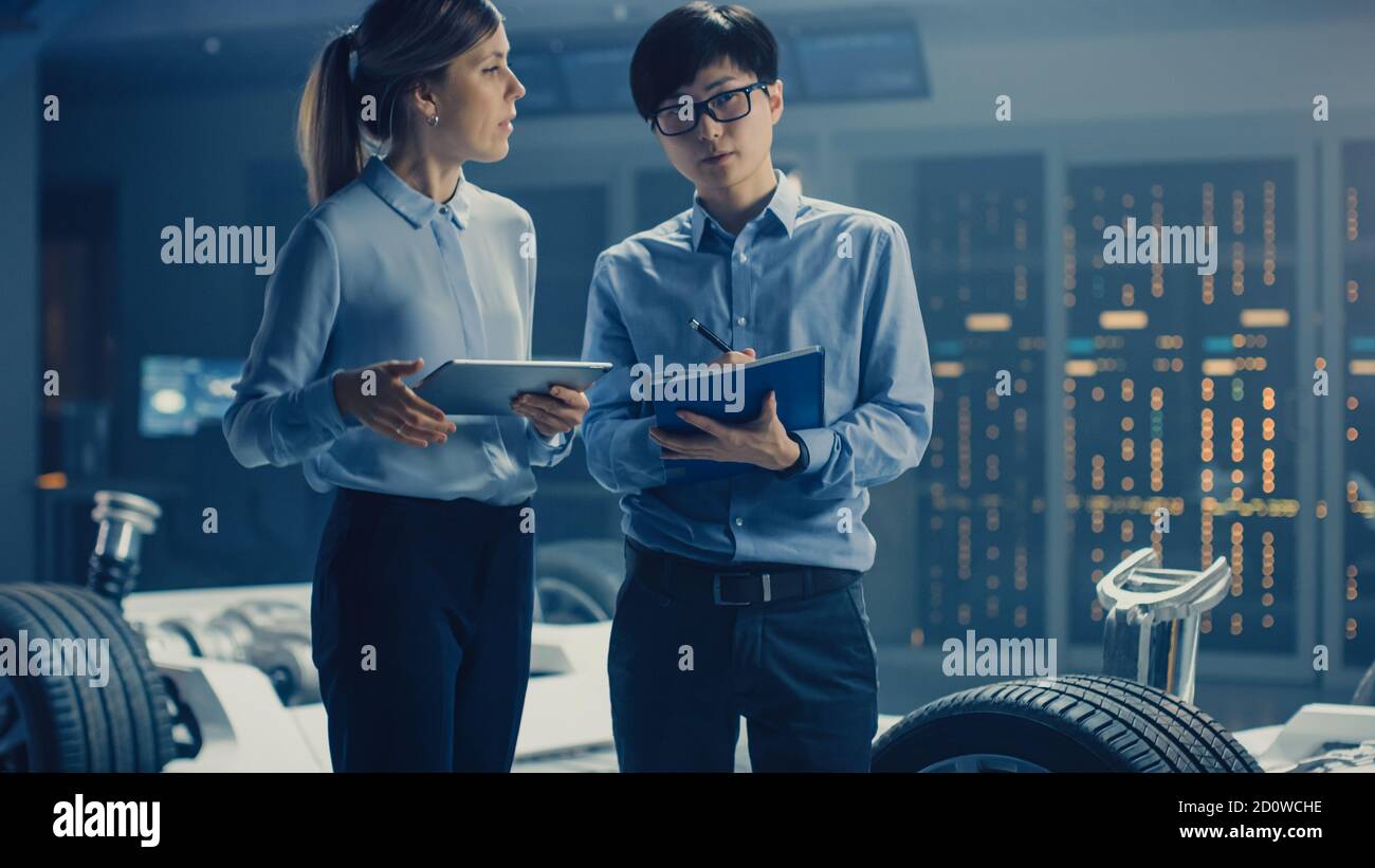 Male and Female Automobile Design Electric Car Engineers Having ...
