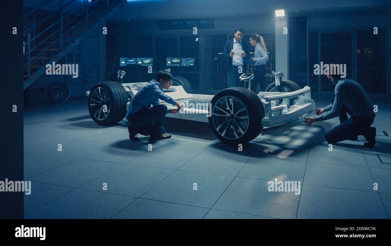 Team of Automotive Engineers Discussing and Designing Electric Car ...