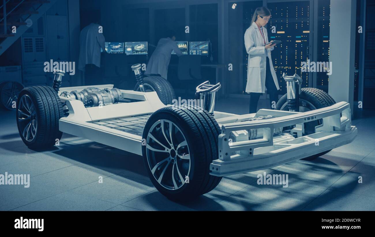 Team of Automotive Engineers and Scientists Discussing, Designing and Working on Electric Car ...