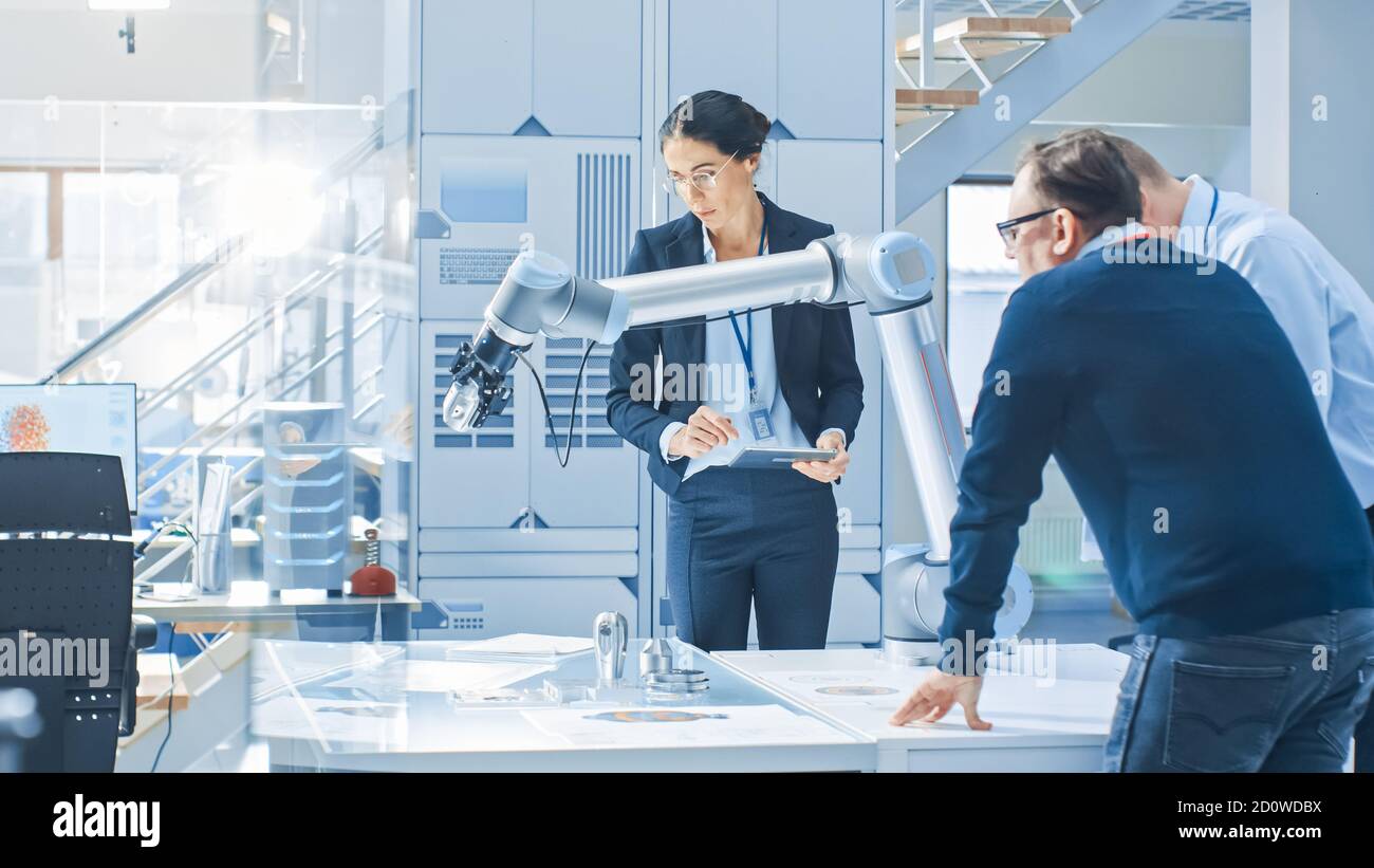 Diverse Team of Industrial Robotics Engineers Gathered Around Table ...