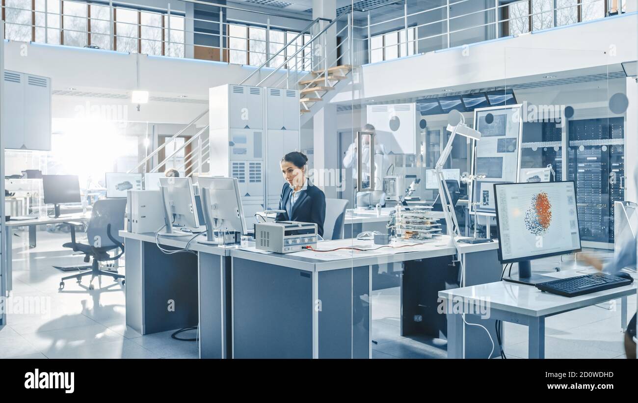 Female Chef Engineer Working on Computer, Programming Robot Arm in ...
