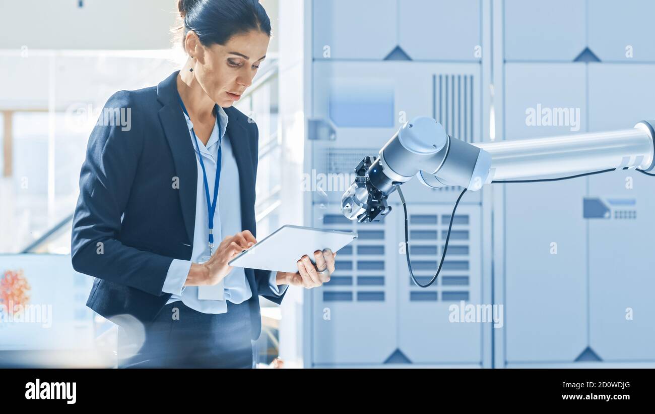 Stylish Female Industrial Robotics Engineer Uses Tablet Computer To