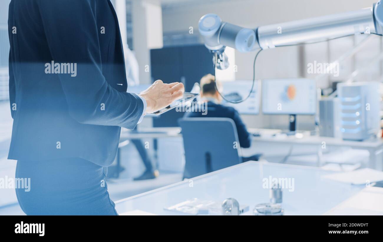 Stylish Female Industrial Robotics Engineer Uses Tablet Computer with ...